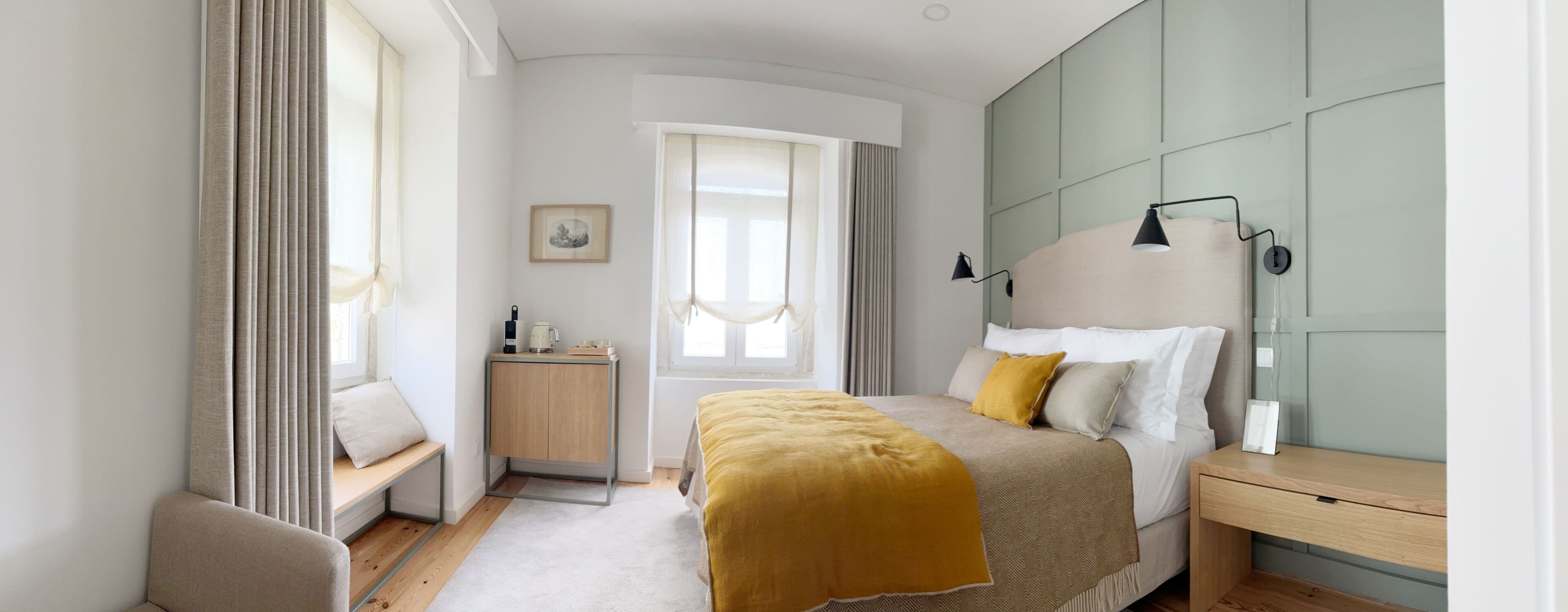 Quarto com cama, mesa de cabeceira, luminária, janela e um pequeno armário.