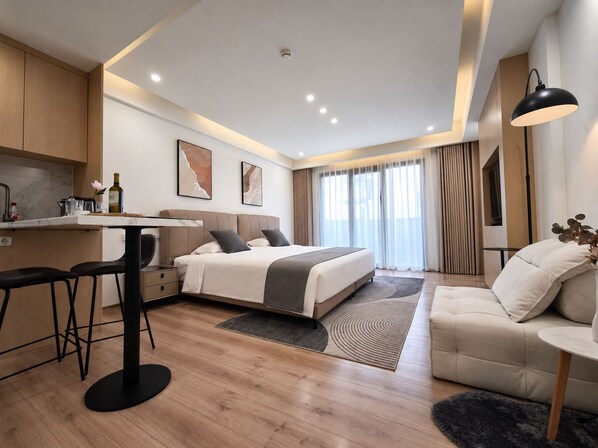 Quarto de hotel moderno com uma cama, escrivaninha e sofá.