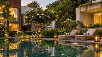Uma área de piscina moderna ao ar livre, com espreguiçadeiras e uma piscina de reflexão.