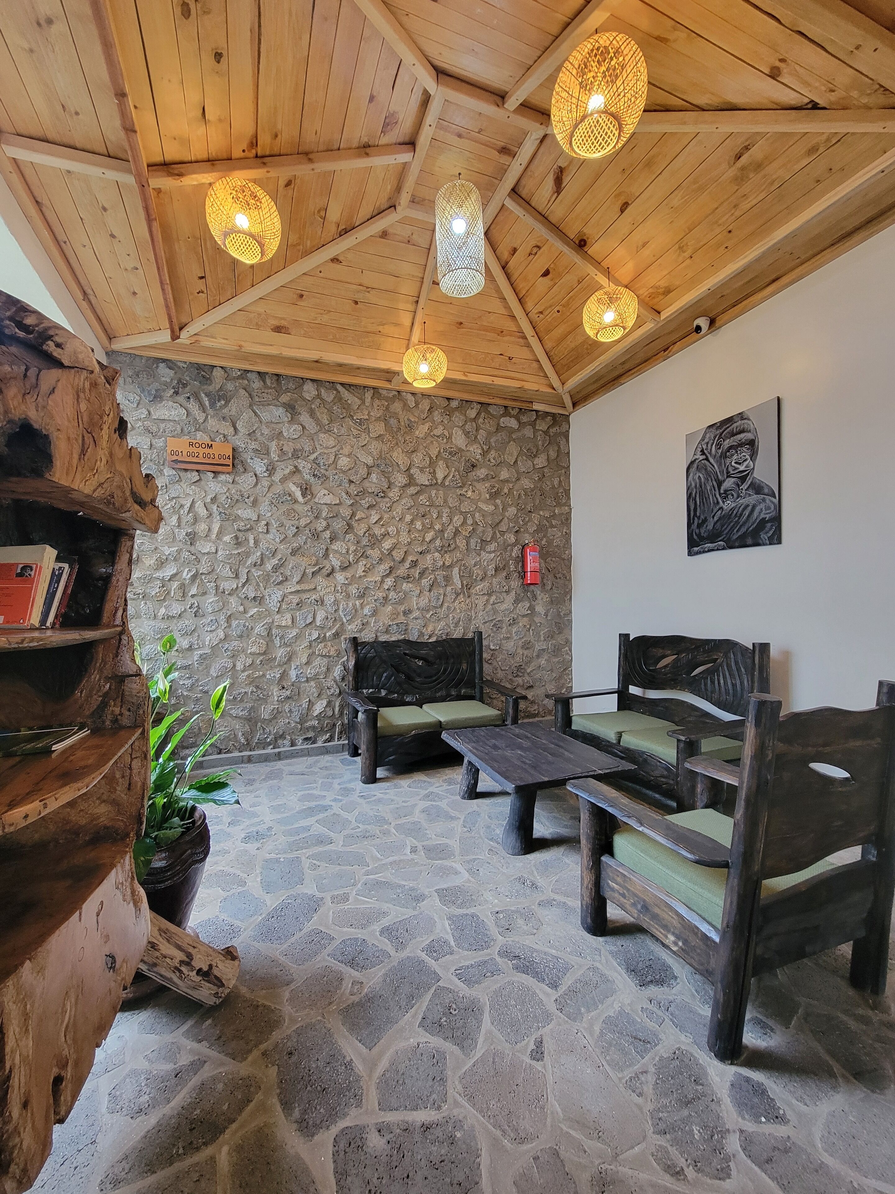 Um quarto rústico com paredes de pedra, móveis de madeira e teto com vigas aparentes.