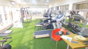 Uma academia com esteiras, bicicletas ergométricas e aparelhos de musculação.