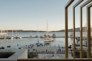 Uma marina com vários veleiros atracados, um barco pequeno e alguns iates.