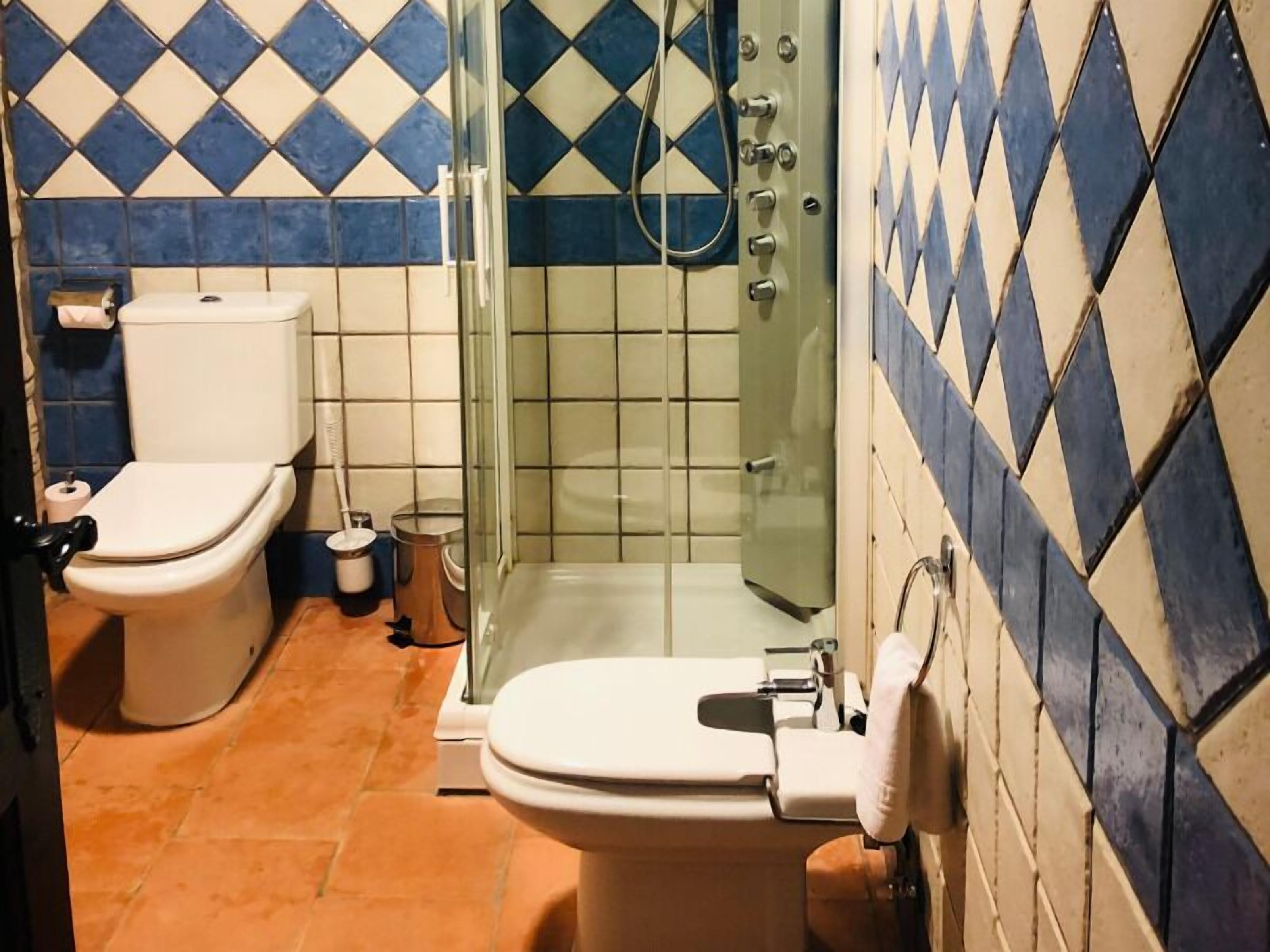 Casa de banho com duas sanitas, chuveiro e lavatório.