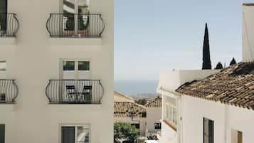 Um edifício de vários andares com varandas, vista para o mar e telhados com azulejos tradicionais.