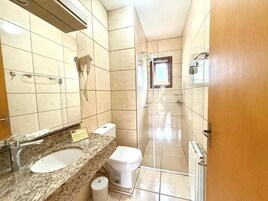 Um secador de cabelo, toalhas fornecidas, sabão, champô 