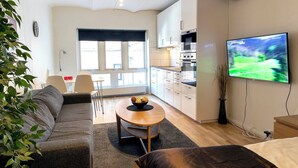 Uma sala de estar moderna com um sofá, uma mesa de centro e uma televisão.