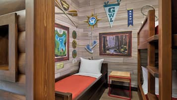 Quarto no estilo de cabana com uma cama, uma mesa pequena e uma beliche.