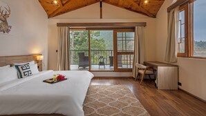 Quarto com uma cama grande, uma escrivaninha e vista para o exterior.