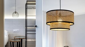 Quarto moderno com cama, uma mesinha e luminária suspensa.