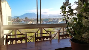 Uma varanda com vista para a paisagem urbana e montanhas.