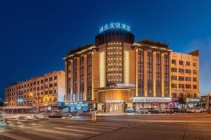 Hotel com vários andares, entrada destacada e sinalização.