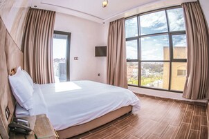 Suíte família, sacada, vista para a cidade | Escrivaninha, Wi-Fi de cortesia, roupa de cama