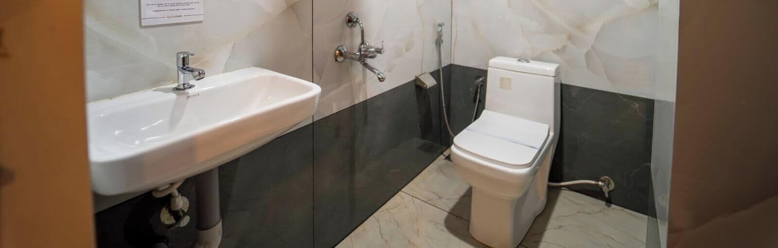 Casa de banho com lavatório branco, sanita e chuveiro.