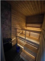 Uma sauna com bancos de madeira e parede de pedra.