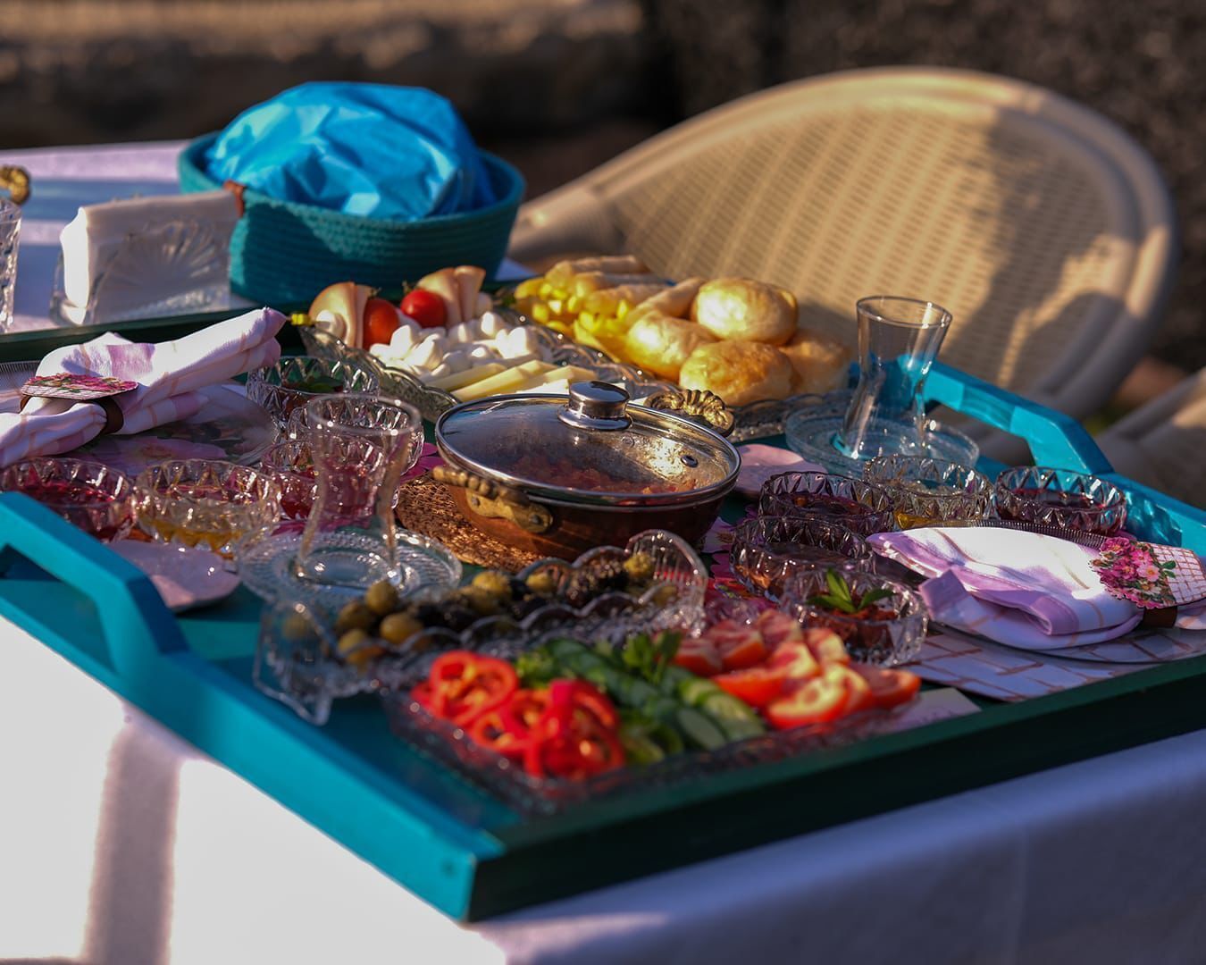 Mesa posta com diversos alimentos e peças de vidro, provavelmente para uma refeição.