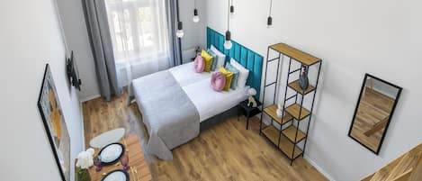 Quarto moderno com cama, mesas de cabeceira, escrivaninha e uma cadeira.