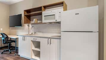 Um frigorífico/congelador grande, um micro-ondas, uma placa de cozinha