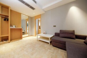 Uma sala de estar moderna com um sofá, uma mesa de centro e prateleiras de madeira embutidas.