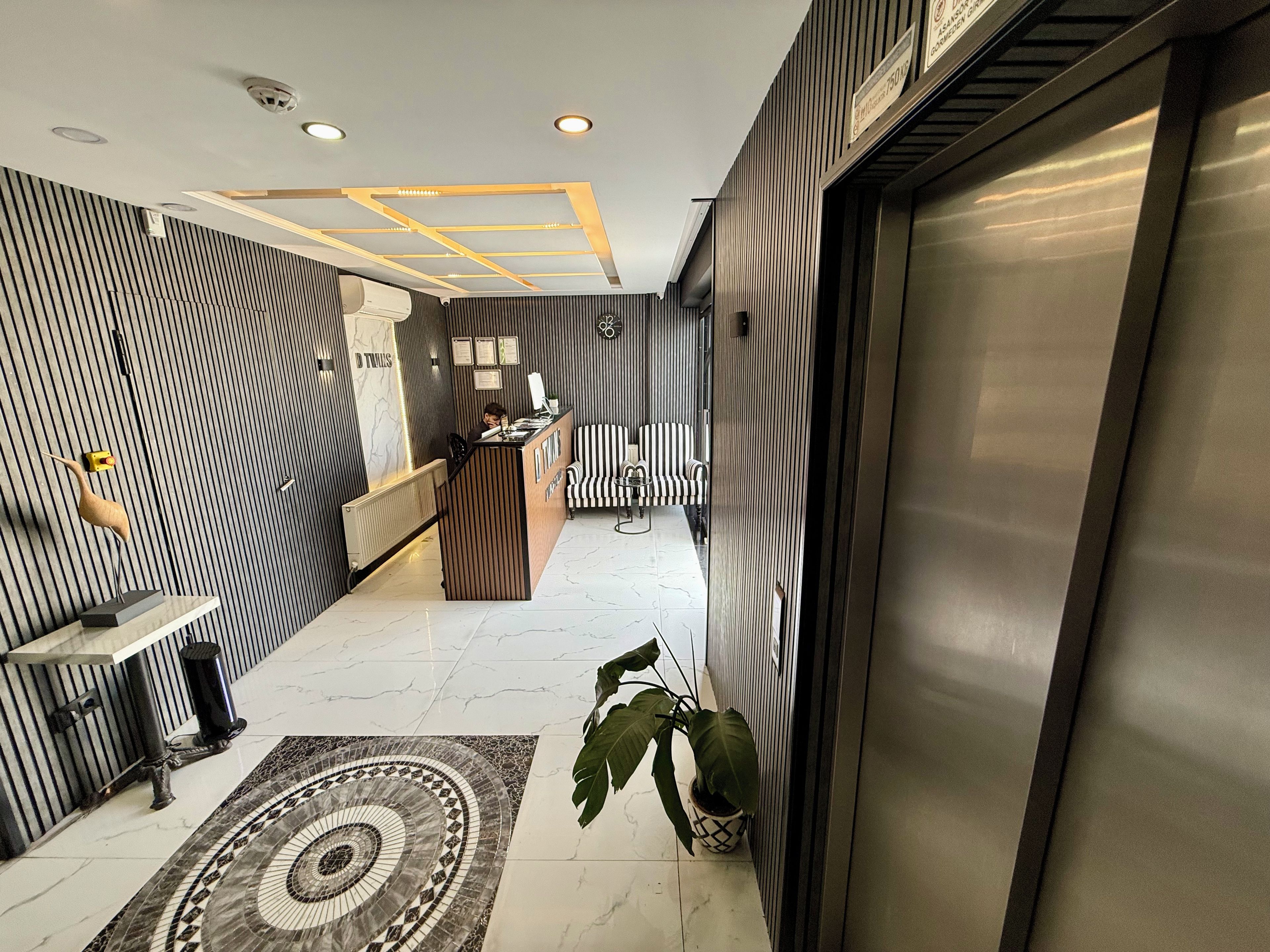 Uma área de recepção moderna com balcão, assentos e piso estampado.