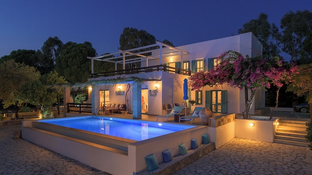 Uma casa moderna com piscina, área de estar externa e um alpendre coberto.