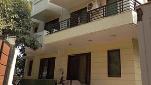 Um edifício residencial com vários andares, varandas, uma escadaria e uma scooter estacionada.