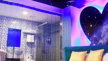 Quarto com cama, chuveiro e parede com design de estrelas.