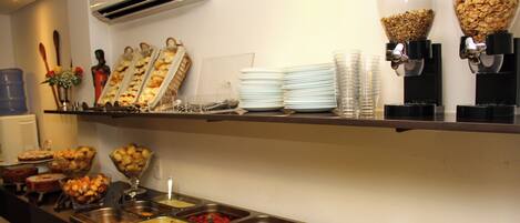 Buffet com diversos alimentos e utensílios.