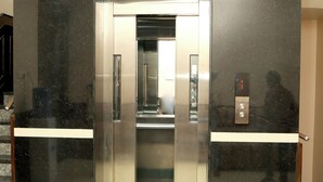 Um elevador com interior metálico e visor digital.