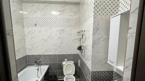 Uma casa de banho moderna com banheira, sanita e lavatório.