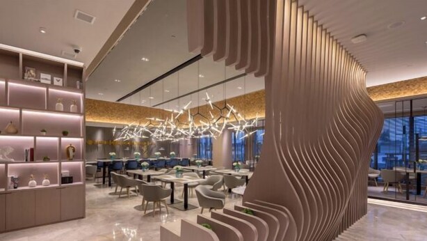 Um interior moderno com uma área de estar central, uma parede decorativa e uma luminária única.