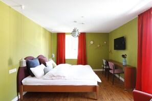Quarto com cama, escrivaninha e cadeira.