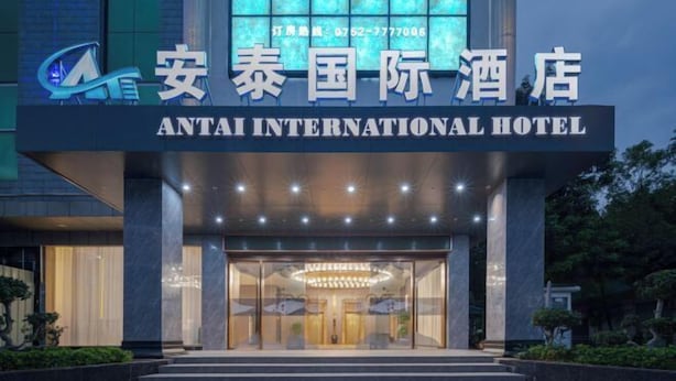 Exterior do Hotel Antai International, com fachada moderna, ampla entrada de vidro e sinalização iluminada.