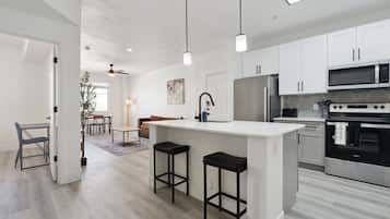 Apartamento luxo, 1 quarto | Cozinha privada | Geladeira, micro-ondas, fogão, cooktop
