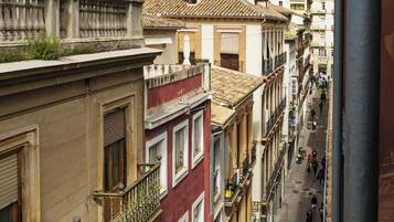 Uma rua estreita flanqueada por edifícios altos, com varandas e arquitetura tradicional.