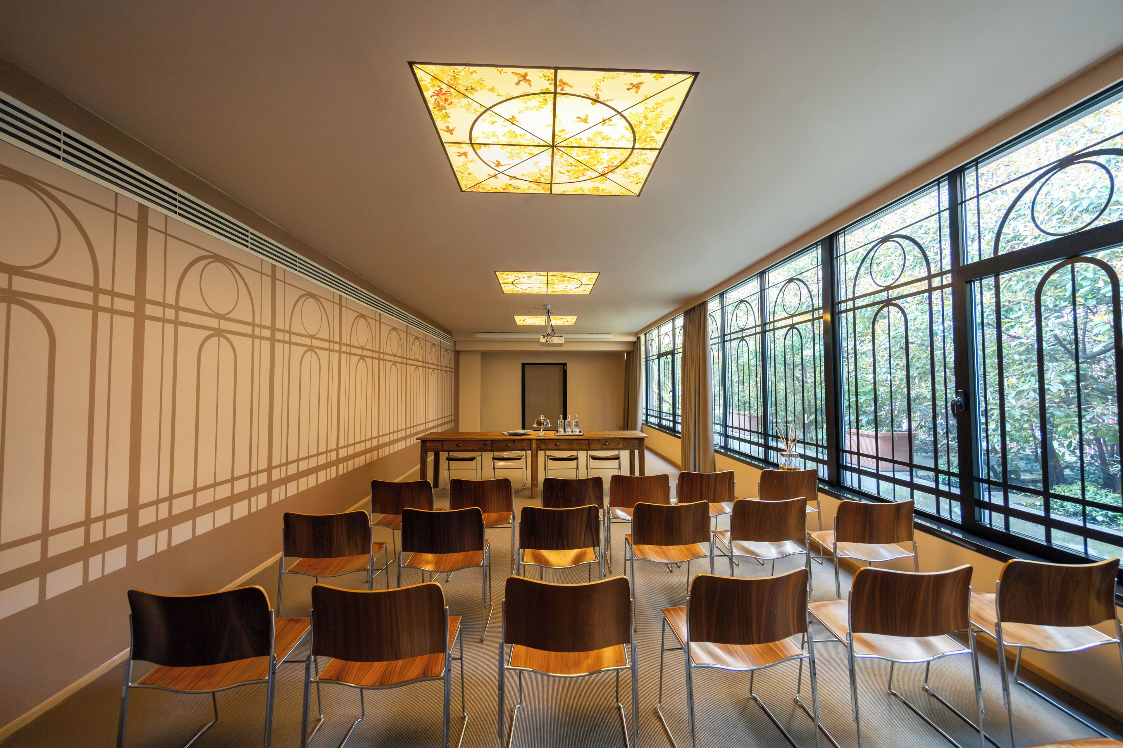 Uma sala de conferências com uma mesa comprida, cadeiras e grandes janelas.