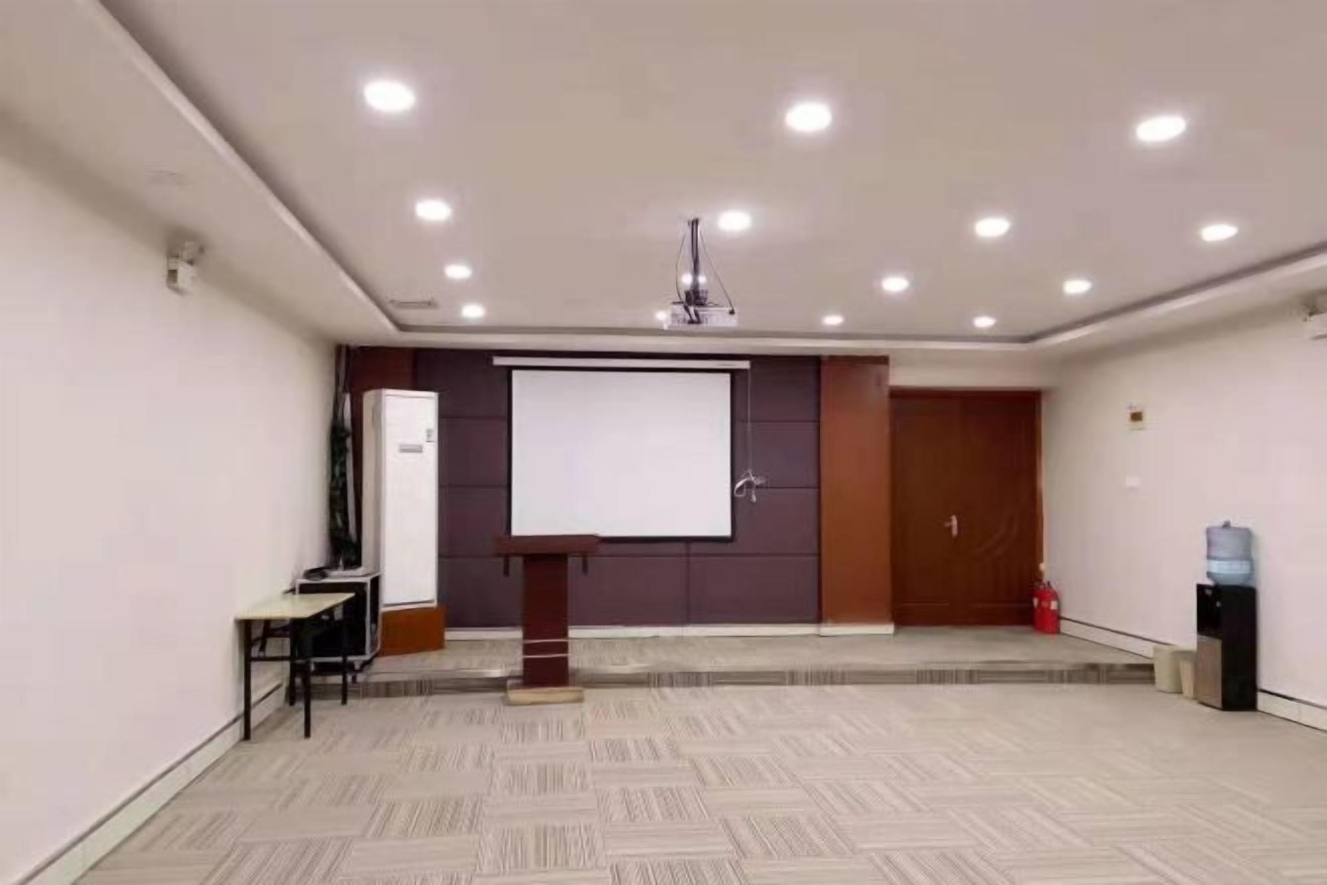 Uma sala de conferências com quadro branco, um palanque e um projetor.