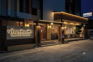 Um edifício com placa indicando restaurante ou café, número de contato e entrada com portão.