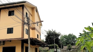 Um edifício de dois andares com teto plano, várias janelas e um alpendre coberto.