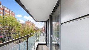 Um apartamento moderno com varanda com vista para uma rua da cidade.
