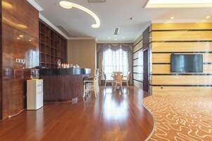 Um hall de hotel moderno, com balcão de recepção, área de estar e carpete estampado.