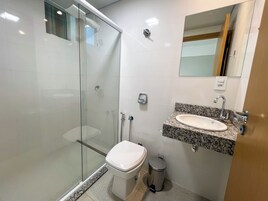 Chuveiro, toalhas de banho, sabonete, papel higiênico