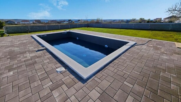 Piscina retangular com borda de tijolos em superfície plana.
