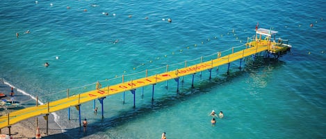 Praia particular, areia branca, guarda-sóis, toalhas de praia