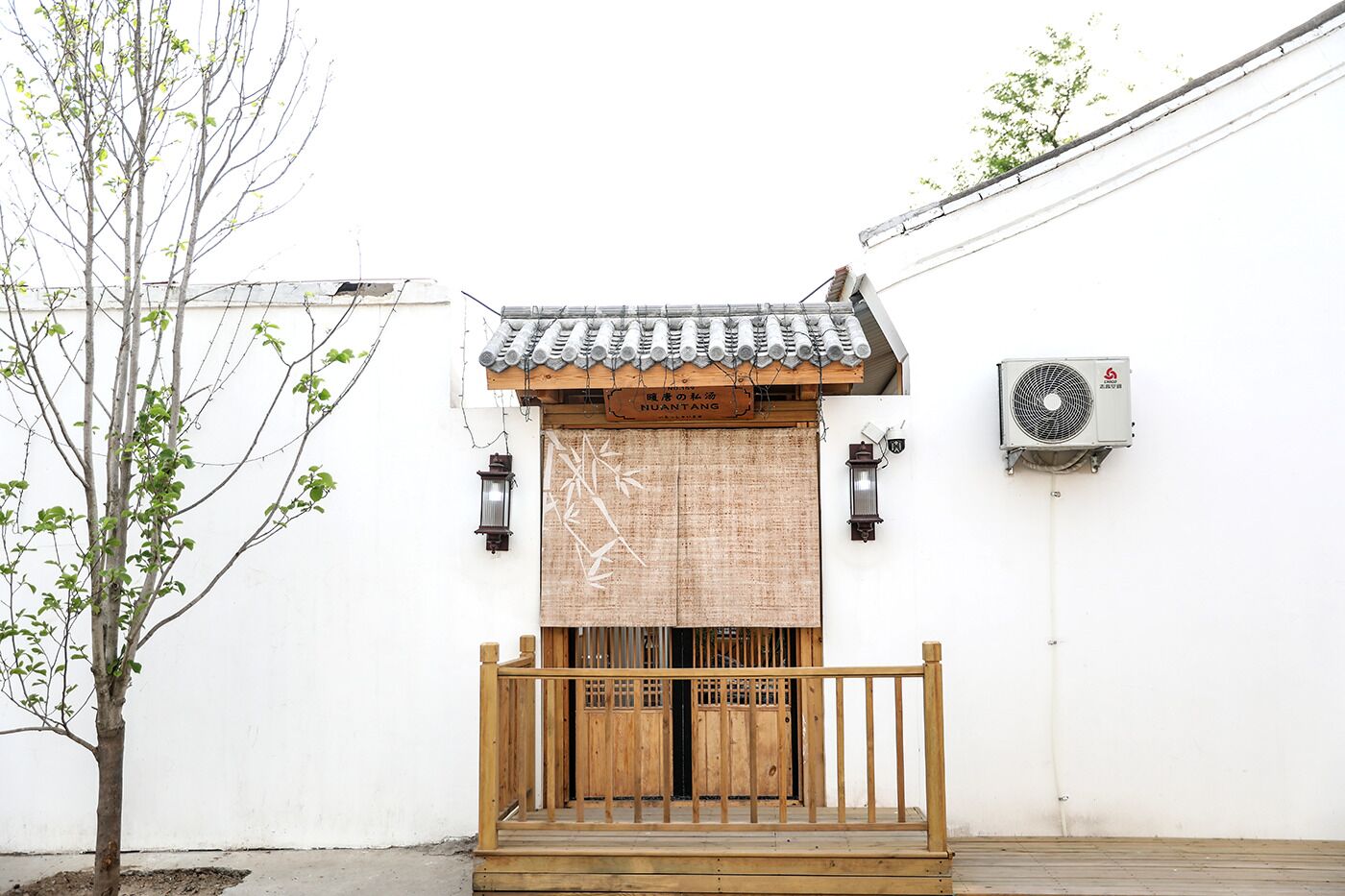 Um edifício japonês tradicional com entrada de madeira, telhado telhado e esteira de bambu pendurada sobre a porta.