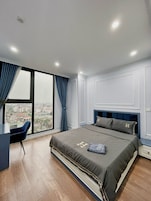 Quarto moderno com cama grande, escrivaninha e uma cadeira.