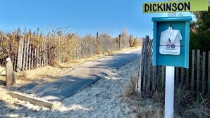 Uma placa indicativa para 'Dickinson' com uma caixa de utilidades azul exibindo uma sacola branca e uma placa azul e branca.
