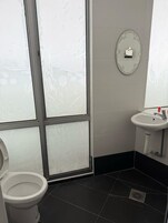 Uma combinação polibã/banheira, toalhas fornecidas, sabão, champô