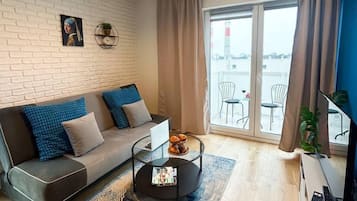 Apartamento conforto, sacada, vista para a cidade | Área de estar | TV 40 polegadas com canais digitais