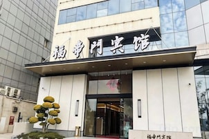 Um edifício moderno com uma placa que diz '福兴门宾馆'.