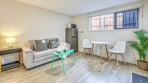 Um espaço compacto com sofá, uma mesinha e um frigorífico.